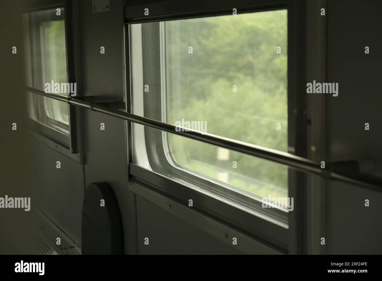 Windows and metal handrails in train car Stock Photo - Alamy