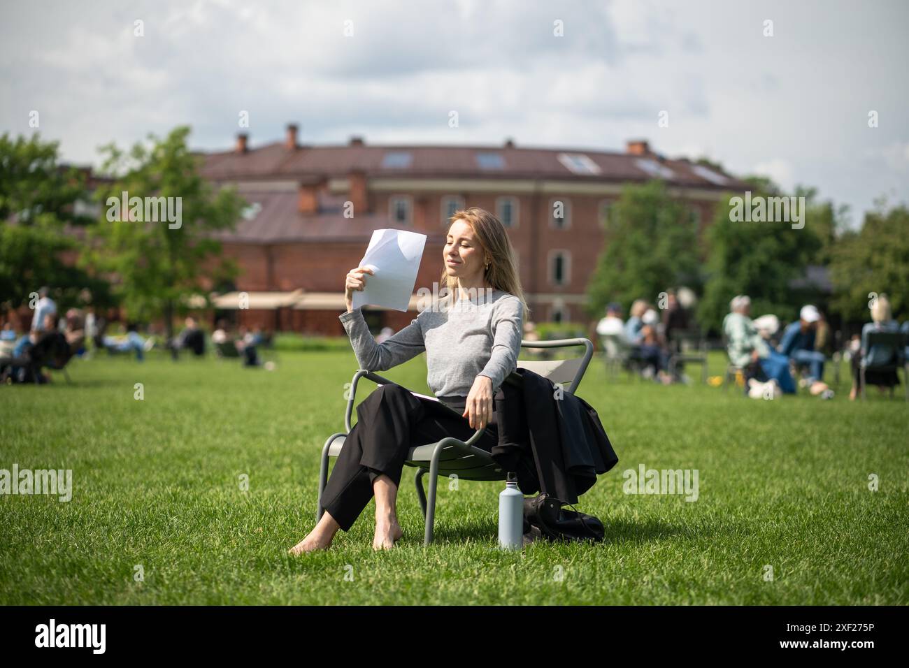 Relaxed pleased woman resting in nature park on lawn outdoors outside ...