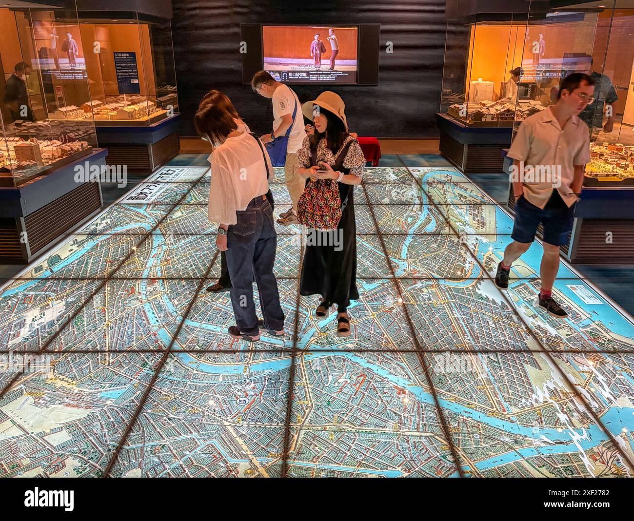 Visitors are viewing a map of Osaka city on the floor during their ...