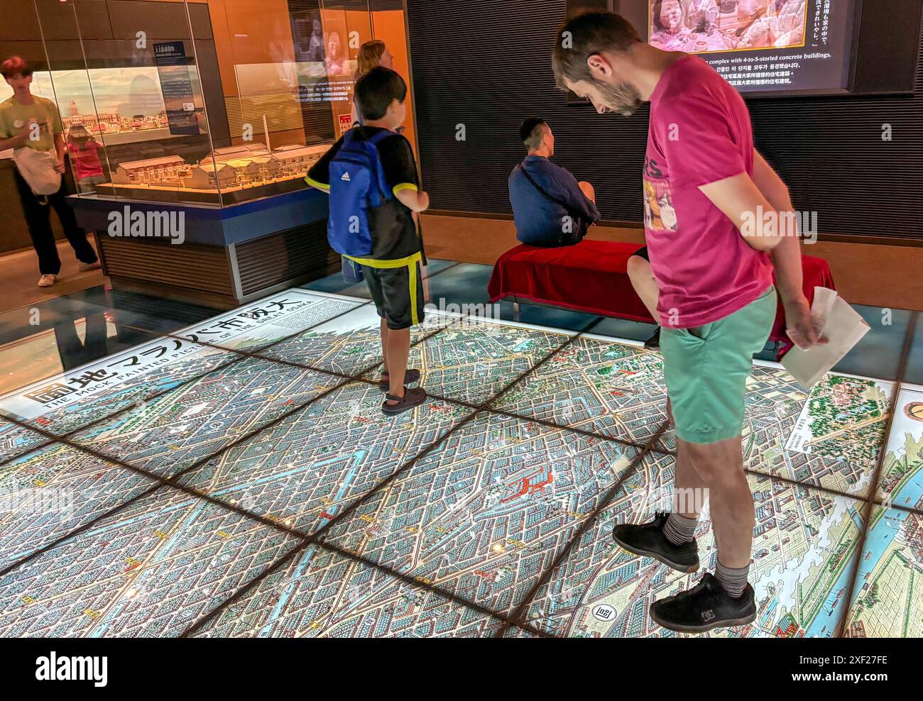 A visitor viewing map of Osaka city on the floor during their visit to ...