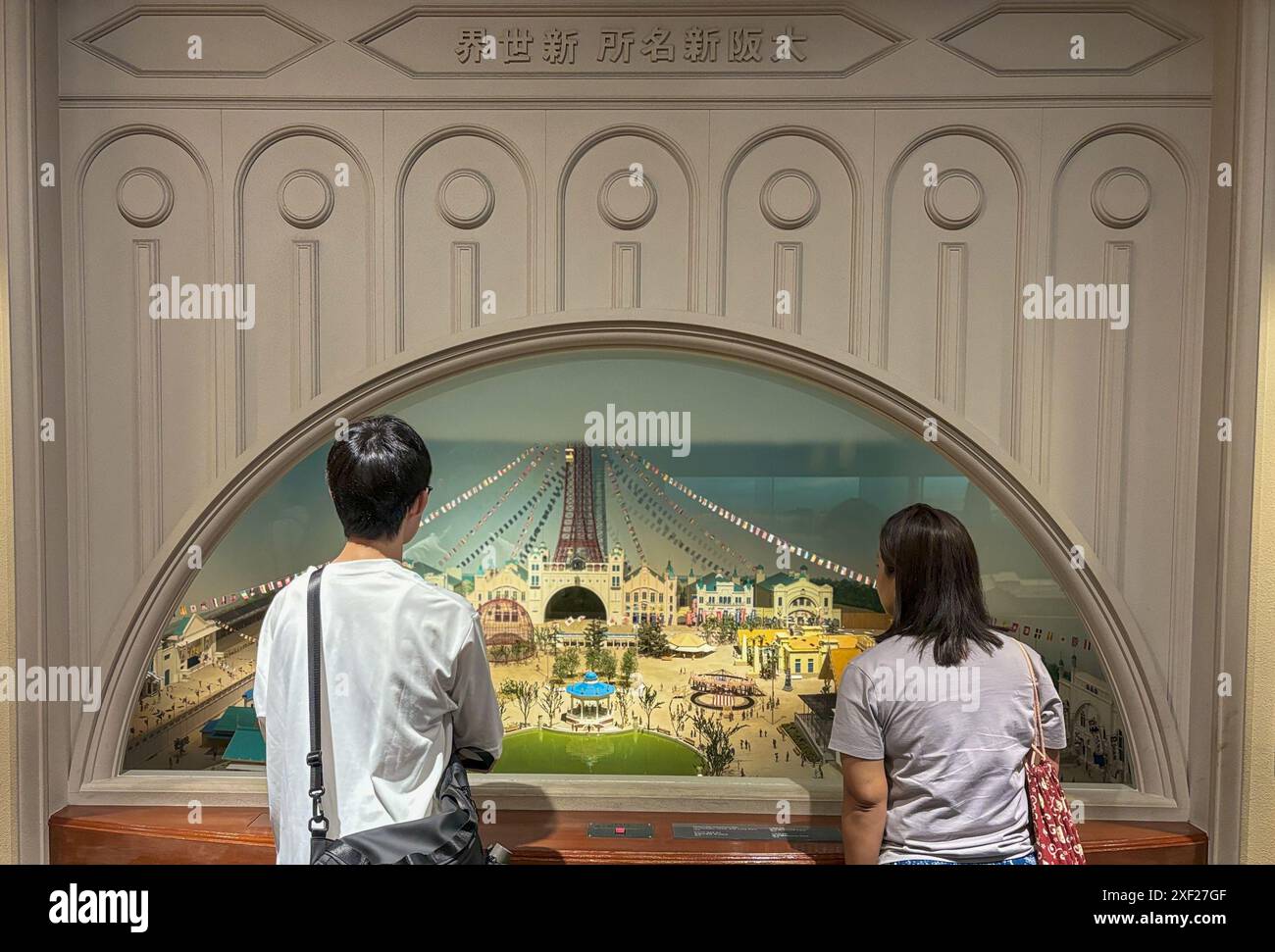 Visitors looking models of Osaka city during their visit to the Osaka ...