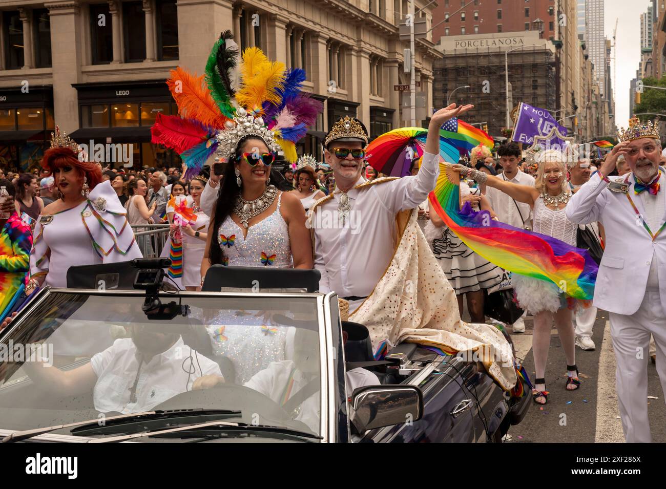 NEW YORK, NEW YORK - JUNE 30: People in costumes ride a car in the ...
