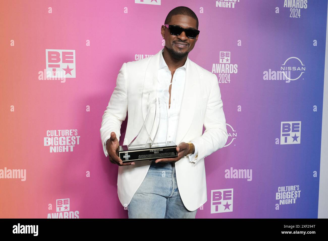 Usher poses with the Lifetime Achievement award in the press room ...