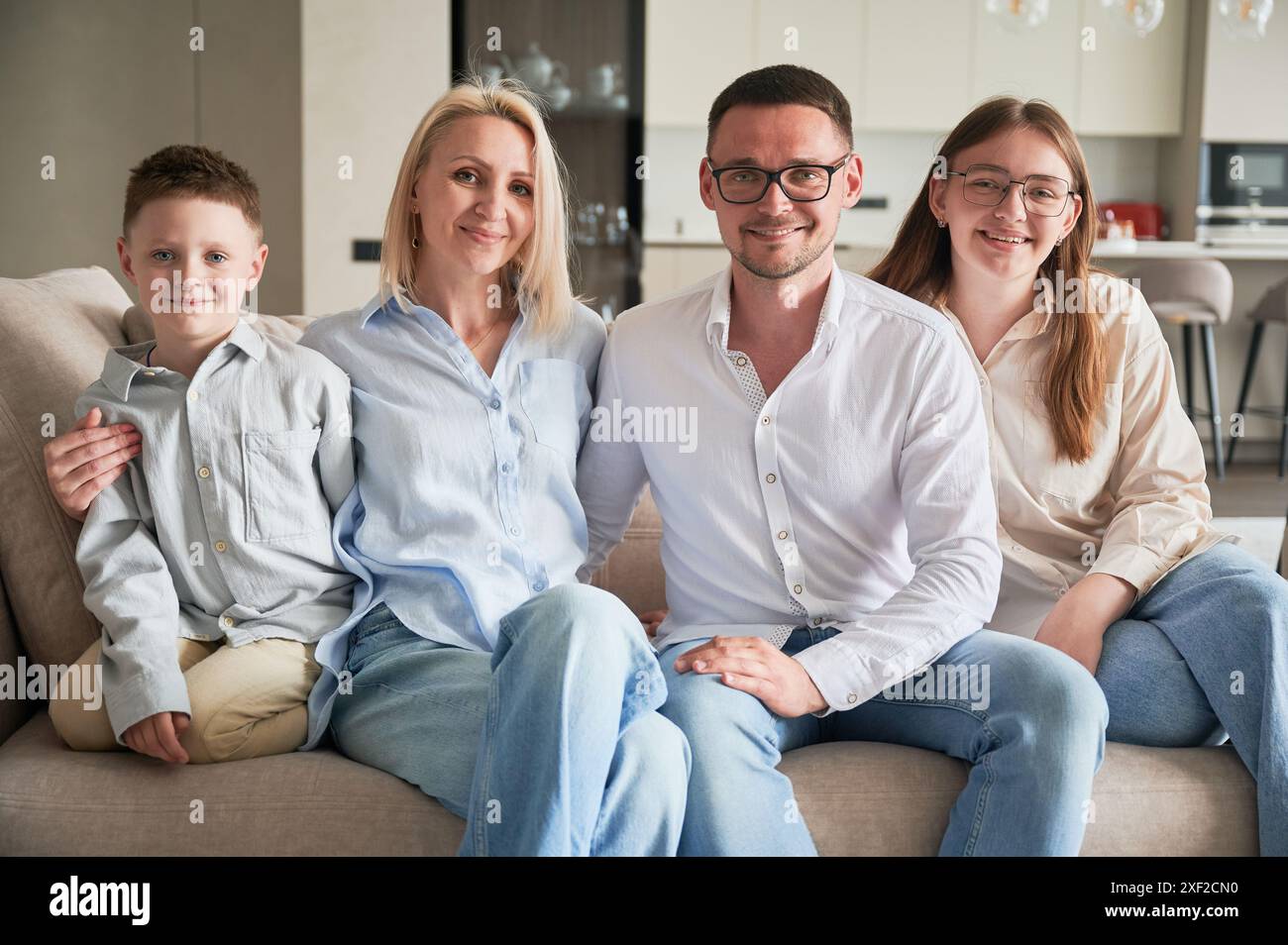 Big family chilling together on cream sofa. Cute family portrait of ...