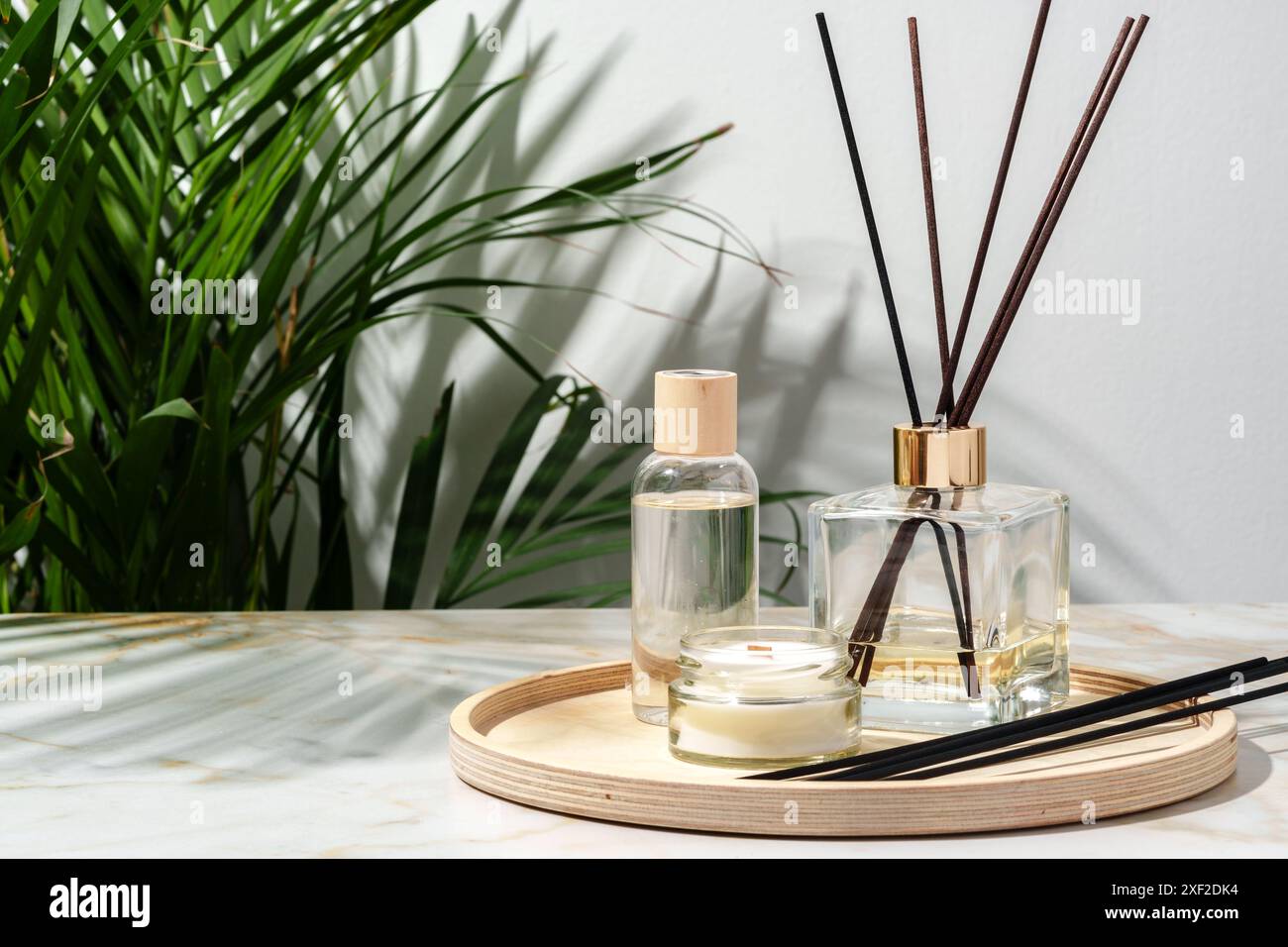Black Reed Diffuser, Amber Candle, and Wooden Tray on White Surface ...