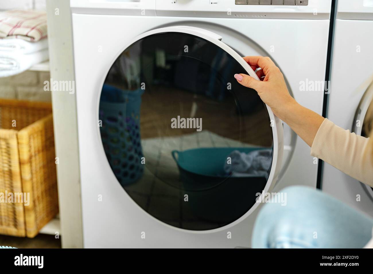 Woman Setting Washing Machine Cycle in Laundry Room Stock Photo - Alamy