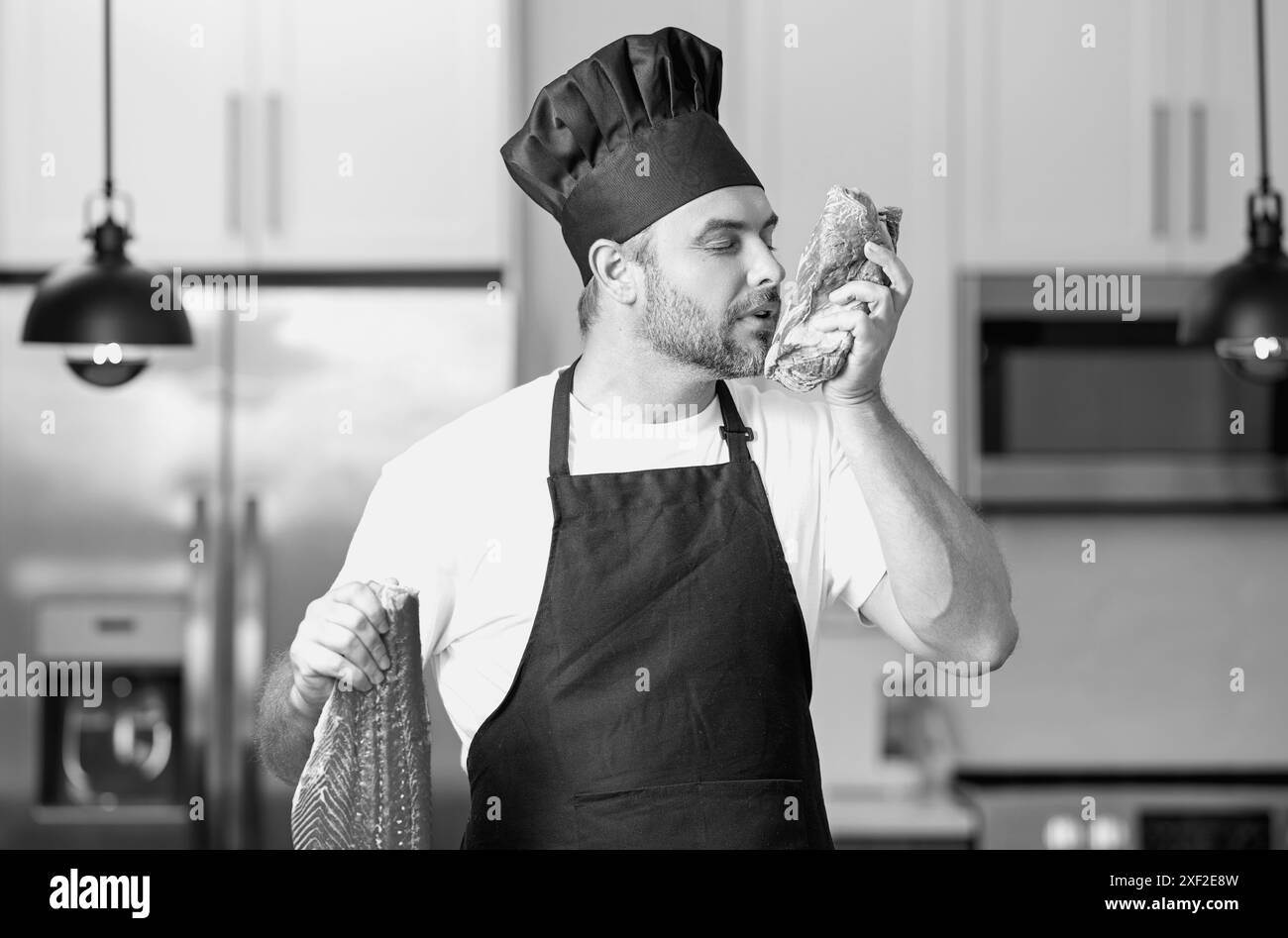 Chef in uniform cooking raw meat beef and fish salmon fillet in the ...