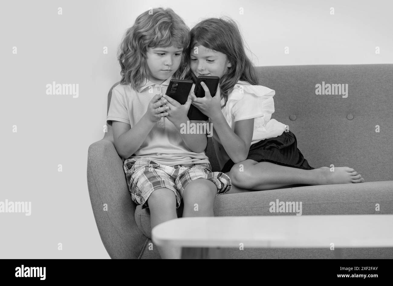 Two kids alone with phone at home. Children friends and friendship ...