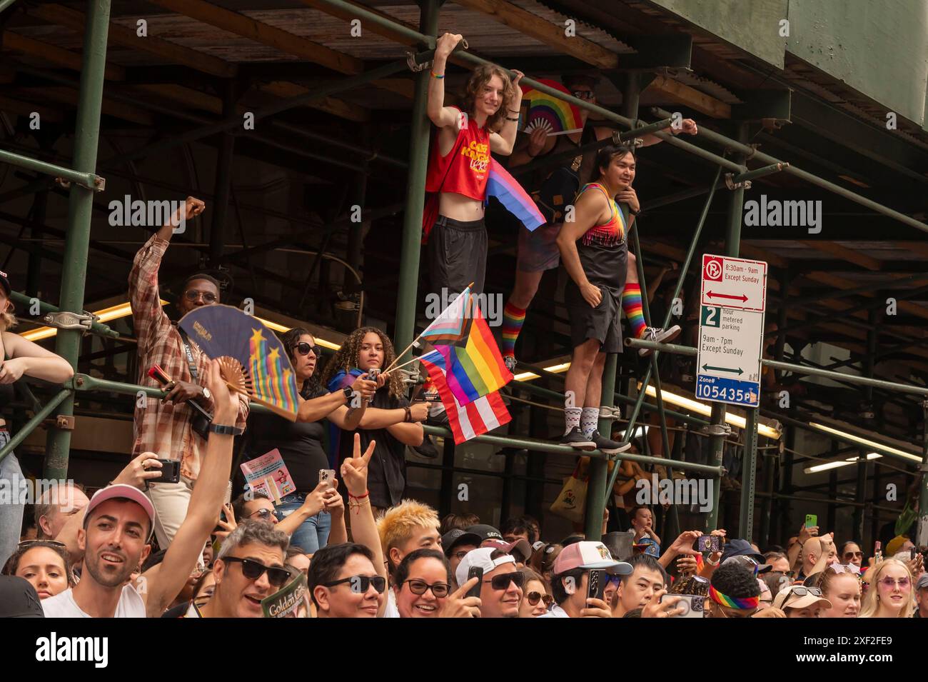 NEW YORK, NEW YORK - JUNE 30: Spectators on construction scaffolding ...