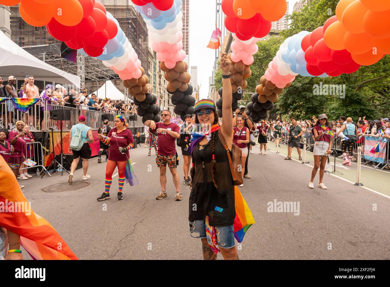 NEW YORK, NEW YORK - JUNE 30: A participant holds a flag under balloons ...