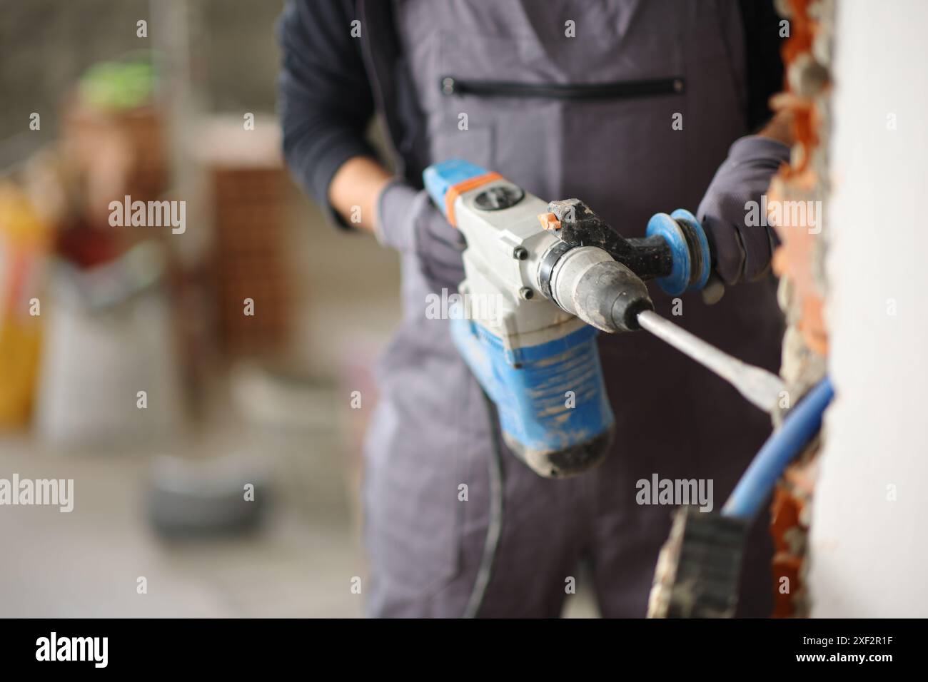 Close up of a construction worker hands using rotary hammer to wreck a ...