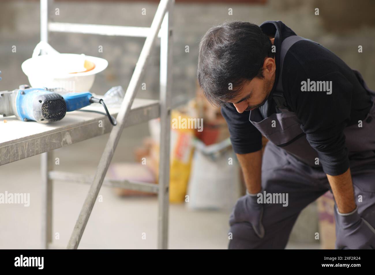 Exhausted construction worker resting in a house under renovation Stock ...