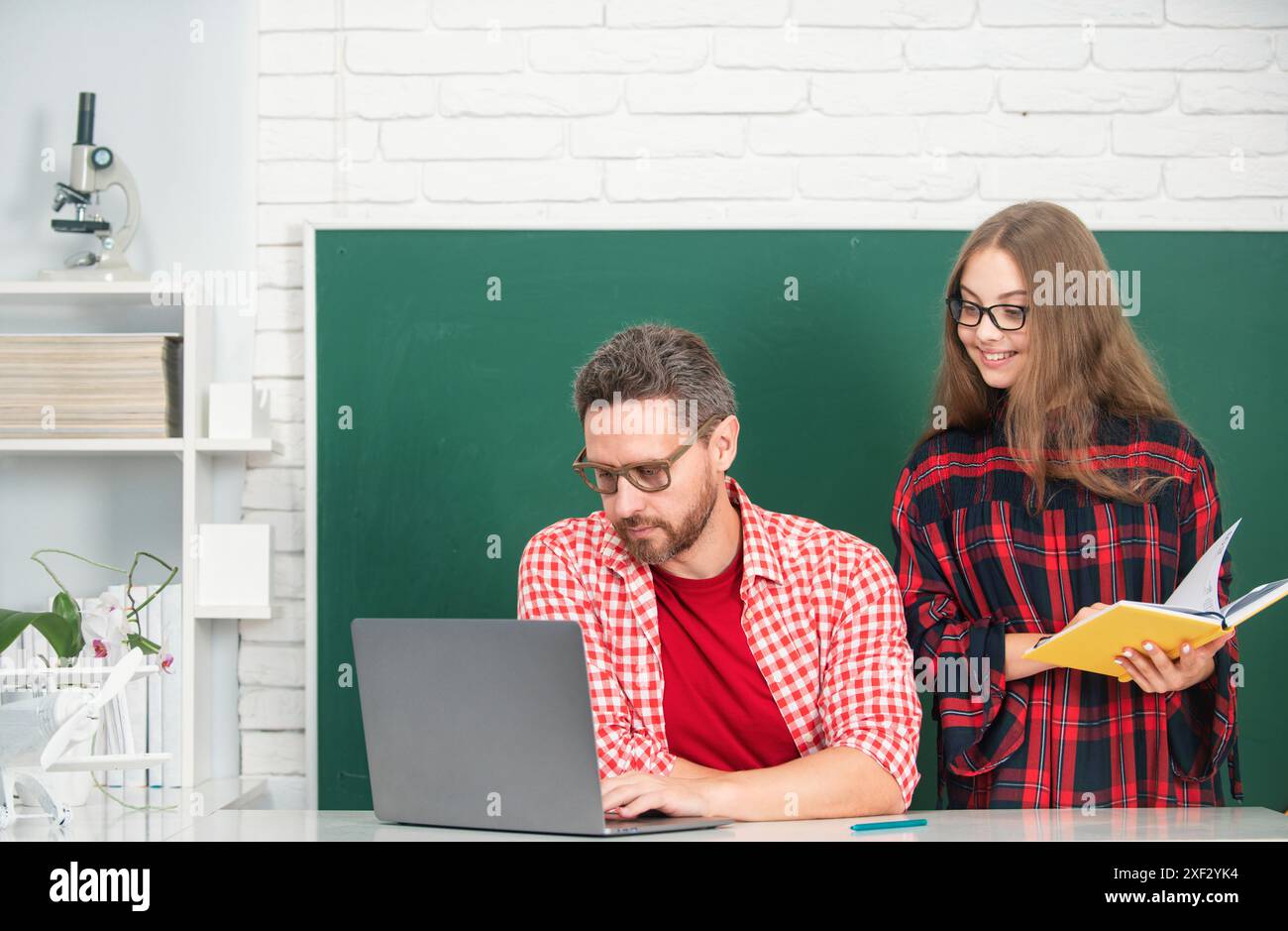 Teacher explains lesson to school child. Elementary school kids ...