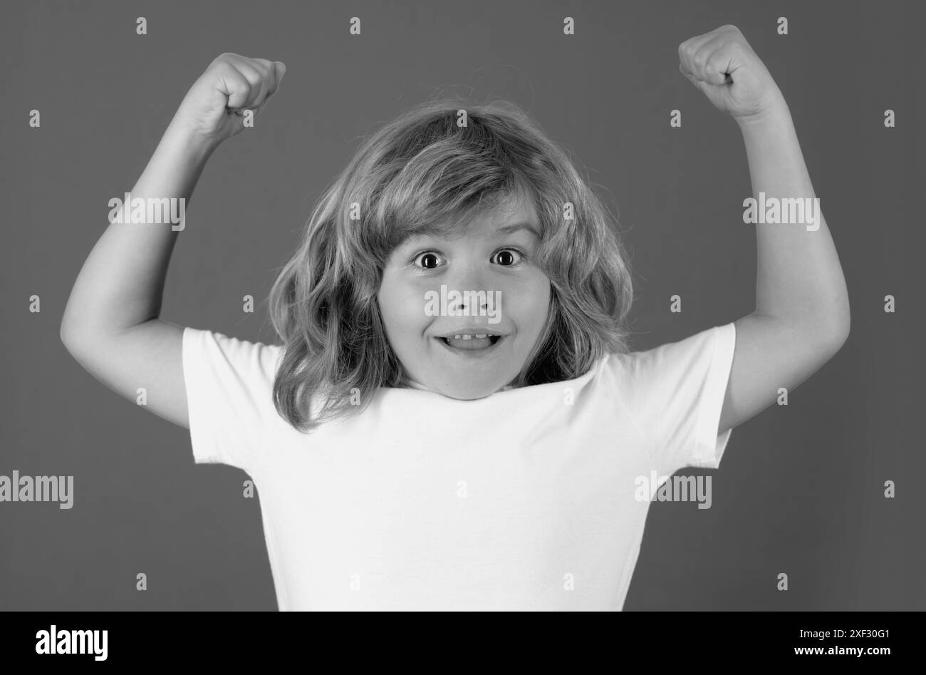 Excited kid boy celebrating victory on studio isolated background ...