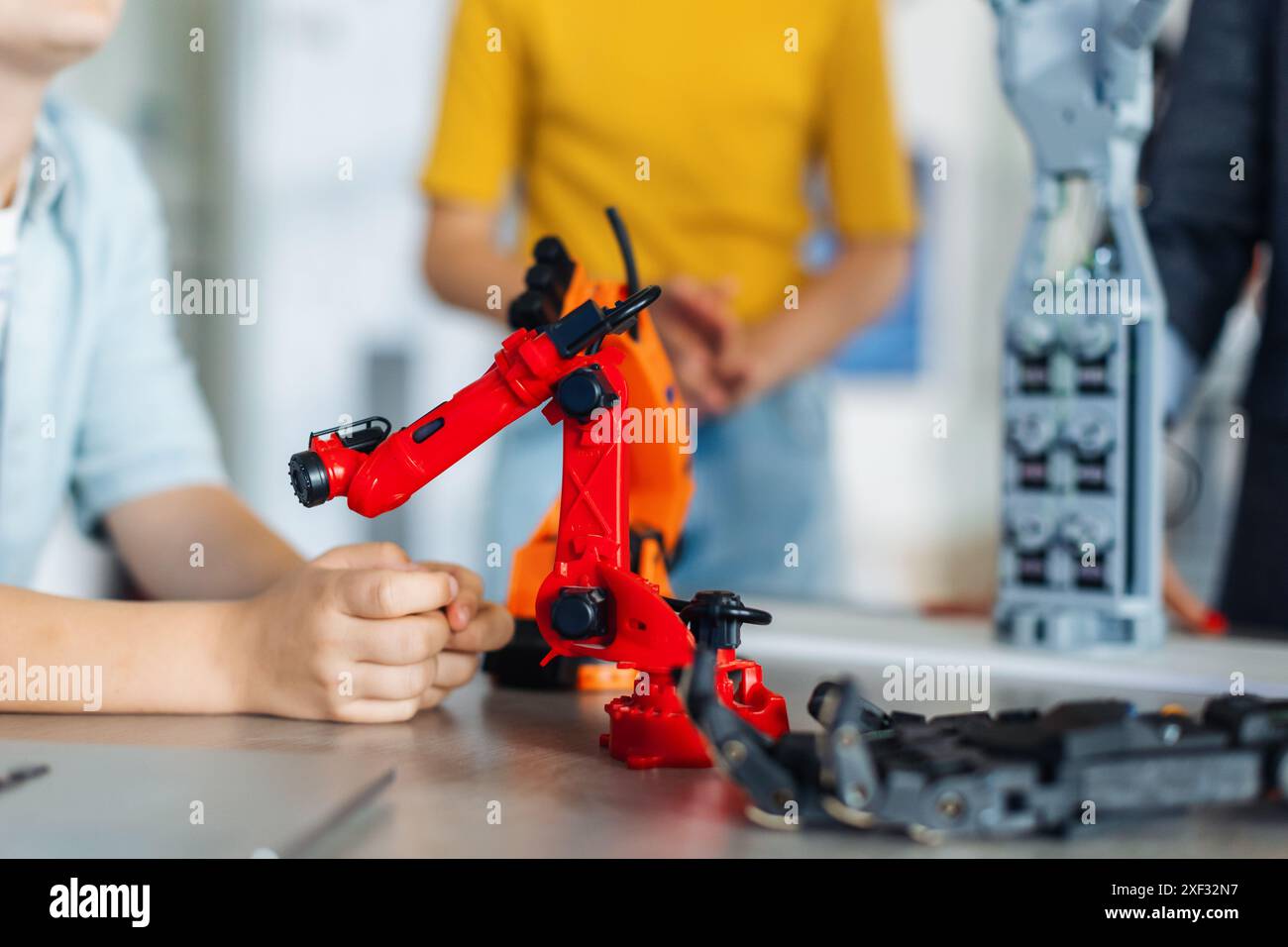 Close up on children looking at small robot, learning robotics in ...