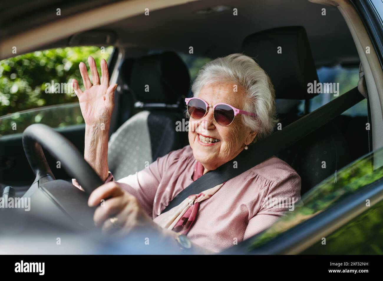 Happy senior woman driving car alone, enjoying car ride. Safe driving ...