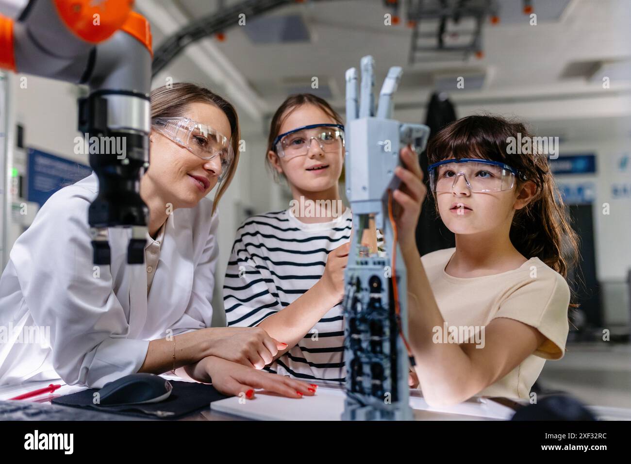 Mom and daughters during take your kid to work day, encouraging them in career in robotics ...