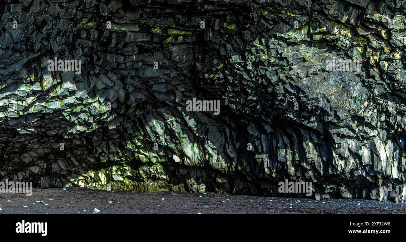 A rocky cliff with a dark shadow on it. The shadow is cast by the sun ...