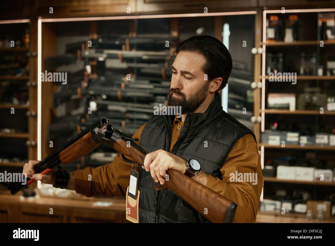 Concentrated salesman checking gun firearm while working at weapon shop ...