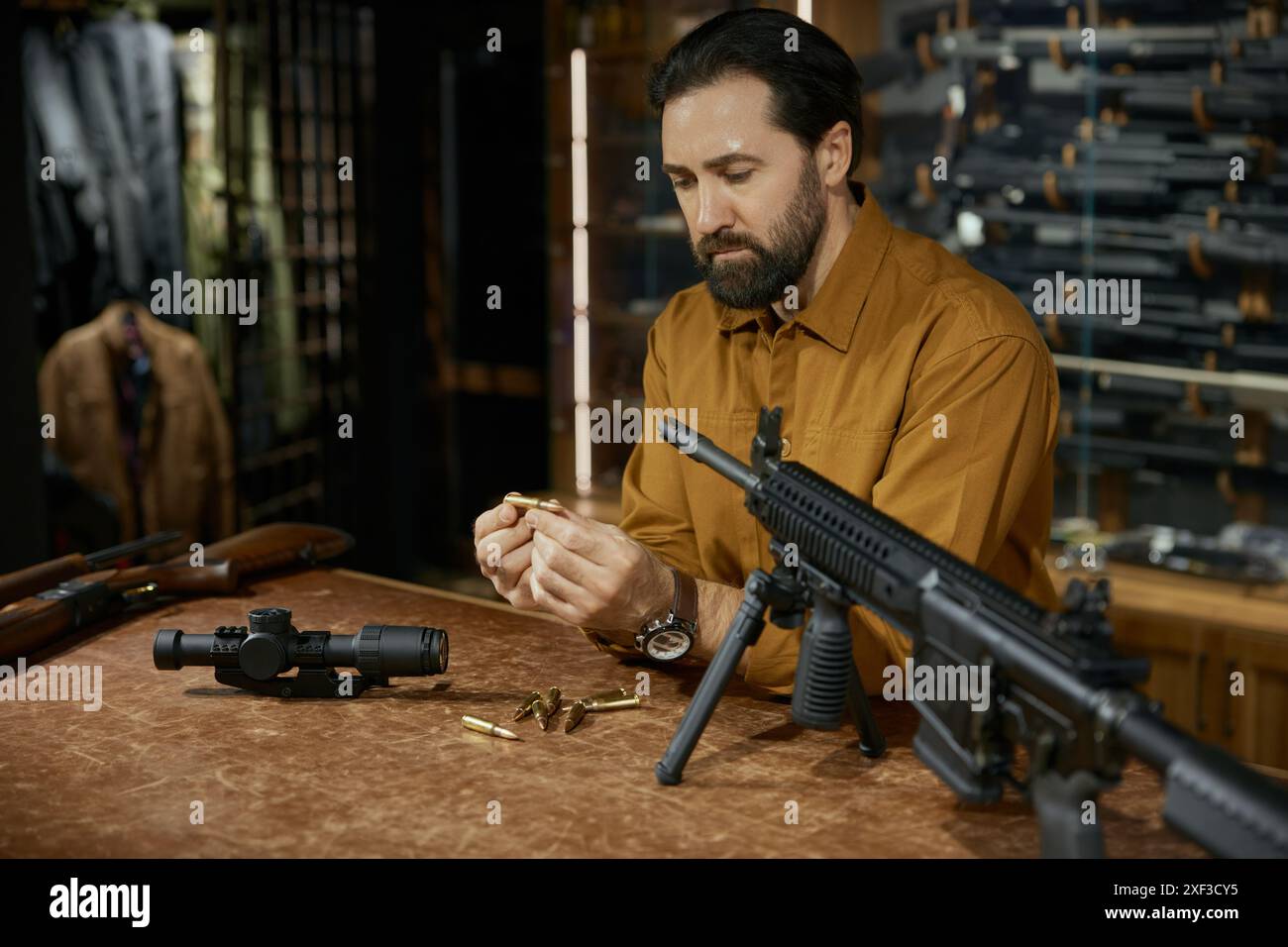 Adult man holding bullets for automatic gun rifle in weapon shop Stock ...