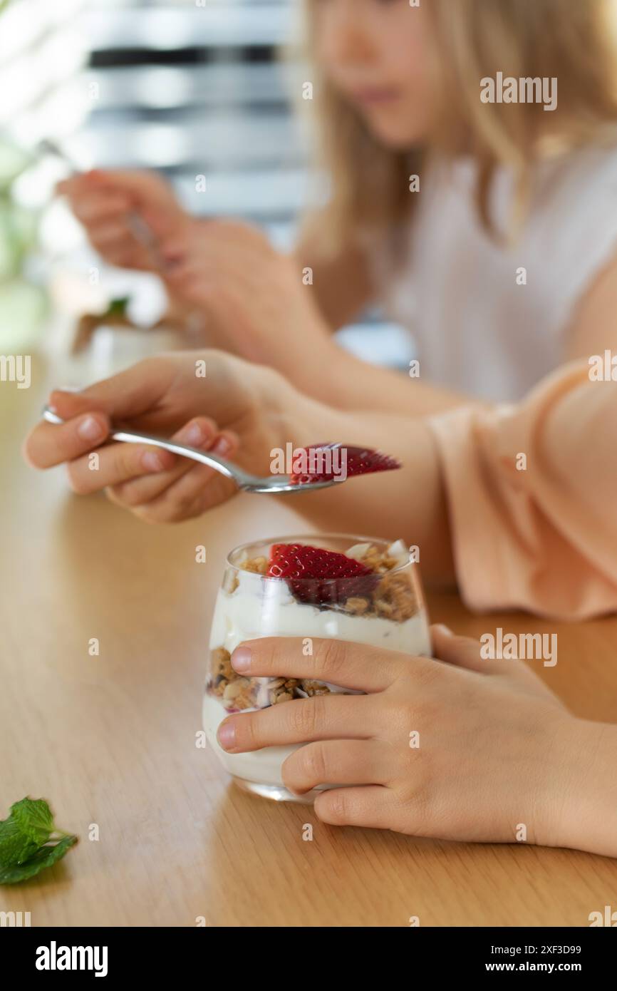 Children enjoy a healthy breakfast of granola with yogurt, decorated ...