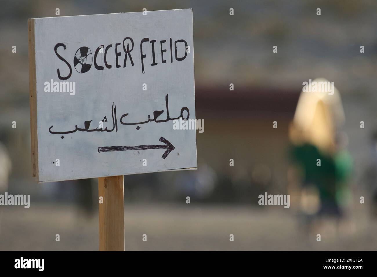 Sign in Arabic and English points direction to soccer field Stock Photo ...