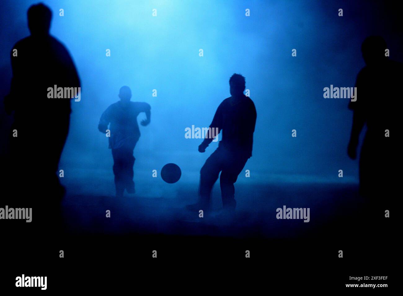 Soccer players in blue light Stock Photo - Alamy