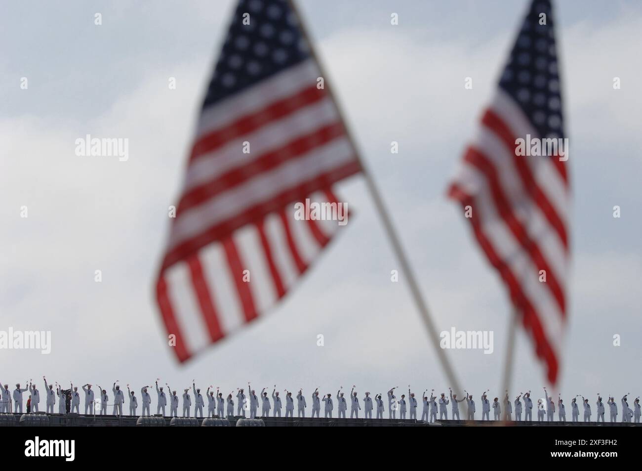American flags in front of a Sailors on a Navy aircraft carrier Stock ...