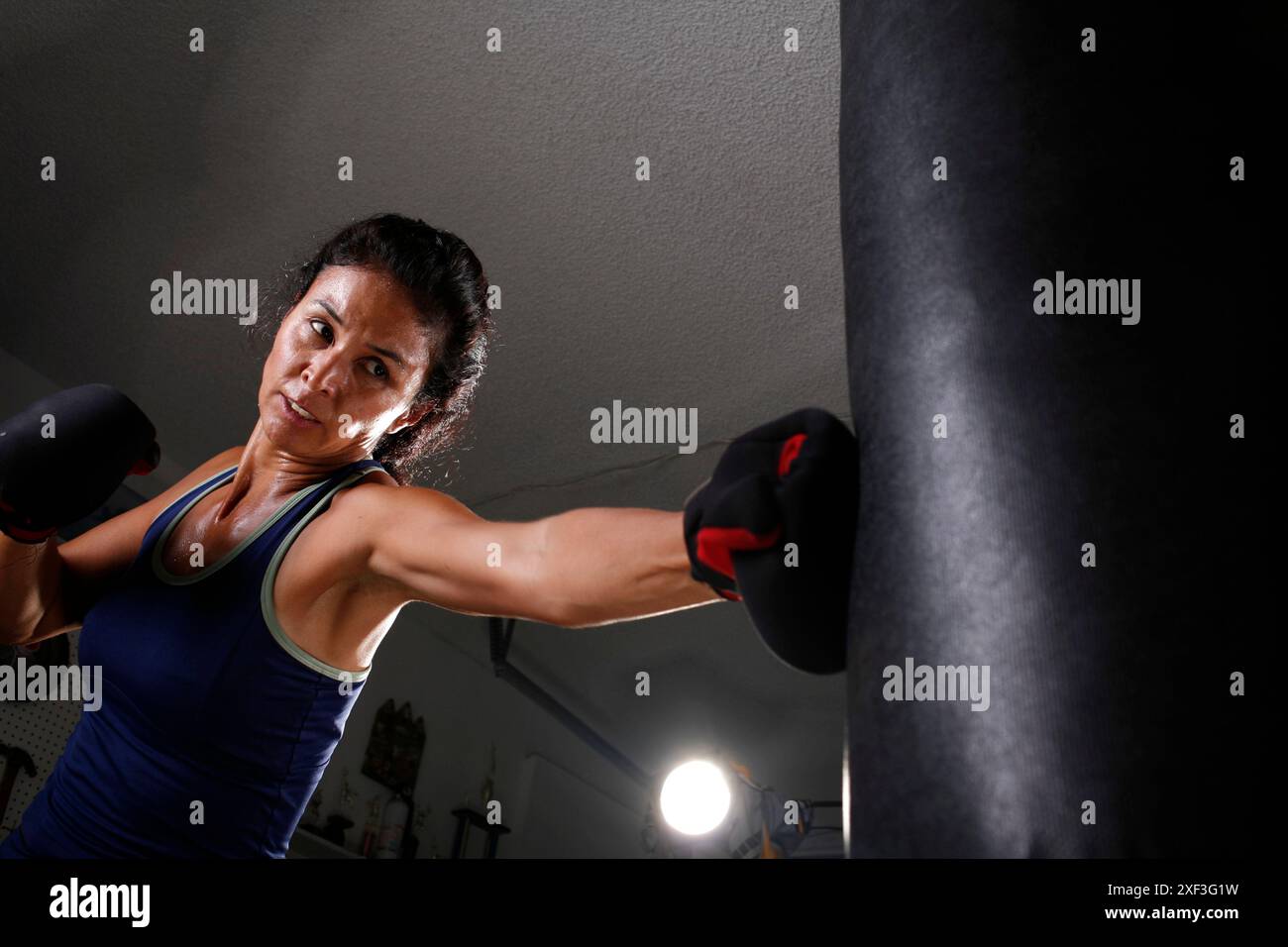 Female boxer hits a punching bag Stock Photo - Alamy