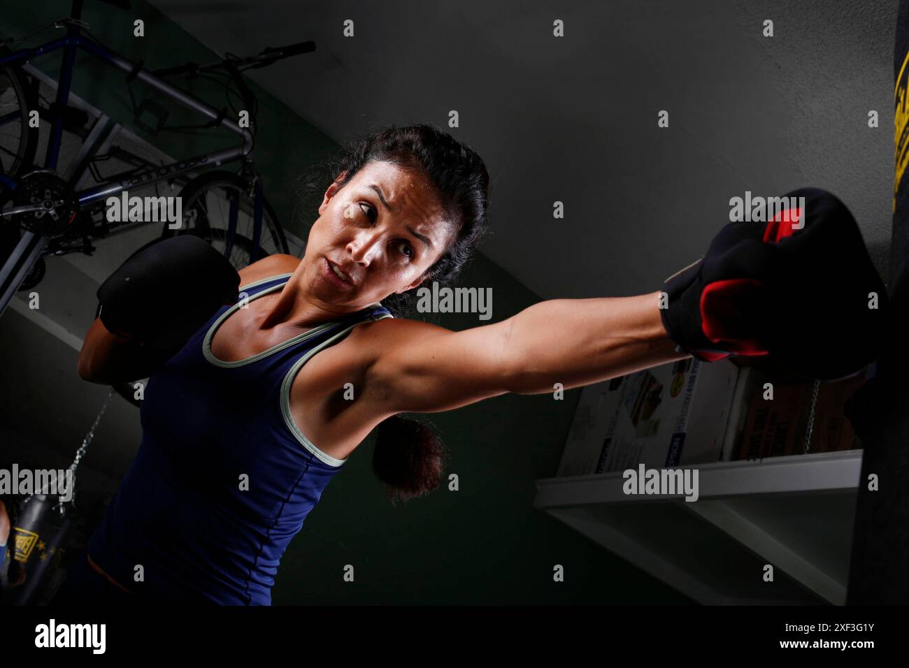 Female boxer hits a punching bag Stock Photo - Alamy