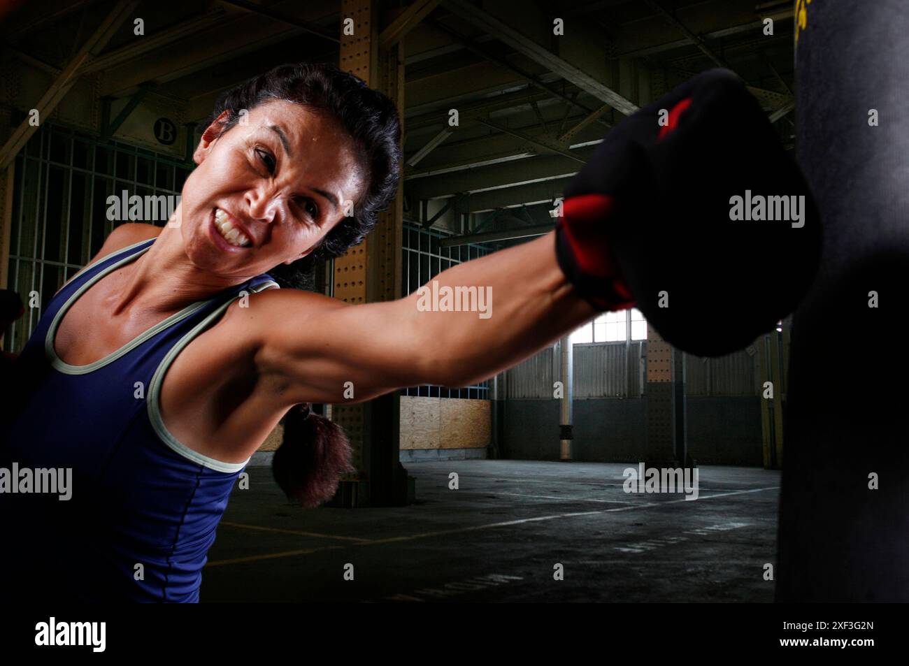 Female boxer hits a punching bag Stock Photo - Alamy