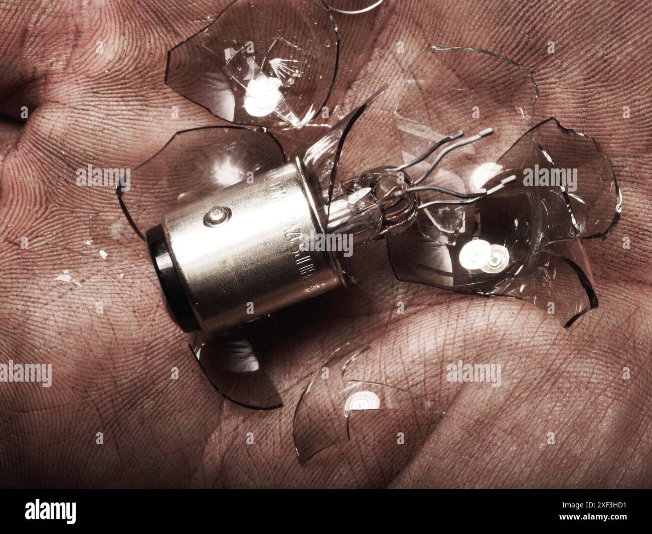Dirty hand holding a broken light bulb Stock Photo - Alamy
