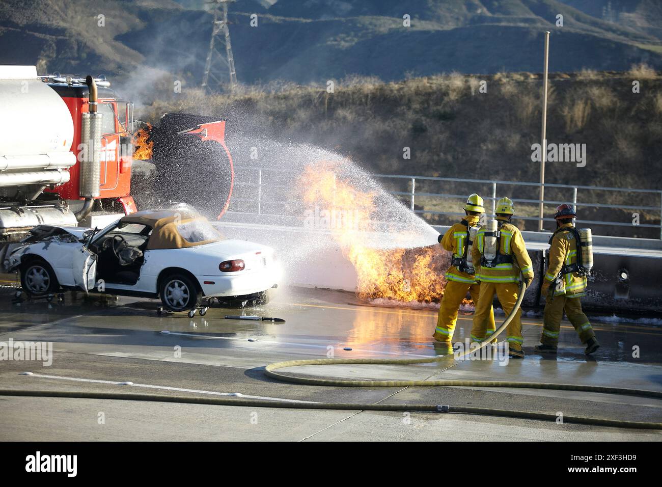 Firefighters put out a fire from a car crash Stock Photo - Alamy