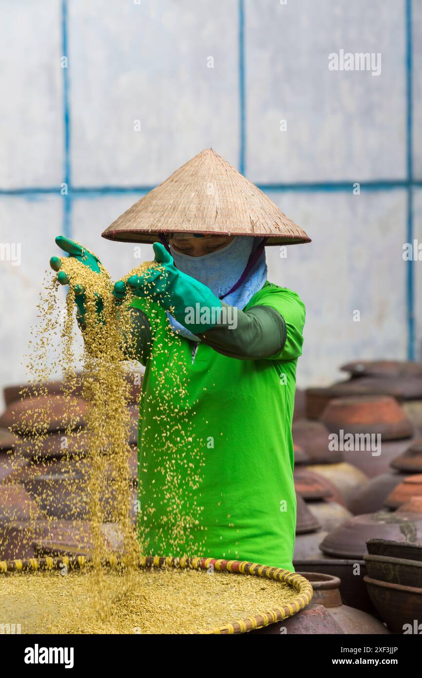Vietnamese woman sifting soya beans at Ban Village soy sauce factory ...