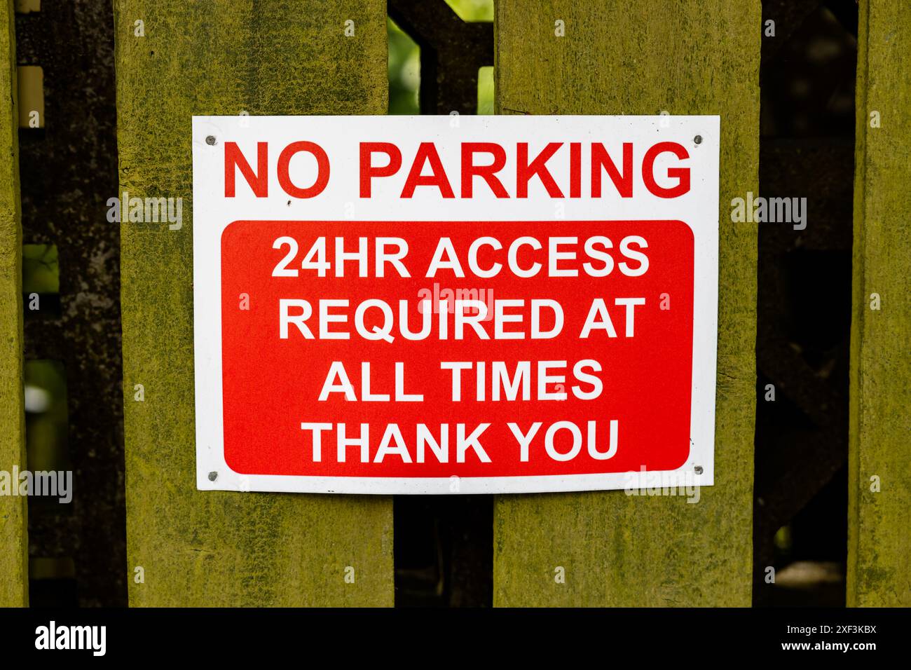 a red and white warning sign for no parking, with 24HR access required ...