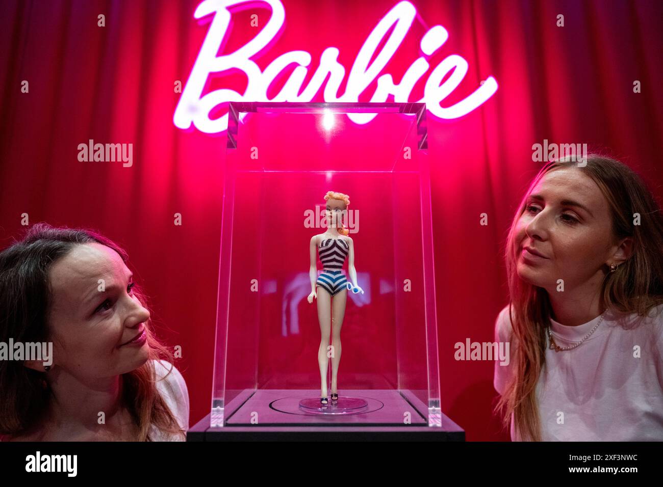 London, UK. 1 July 2024. Staff members with 'Number 1 Barbie', 1959 ...