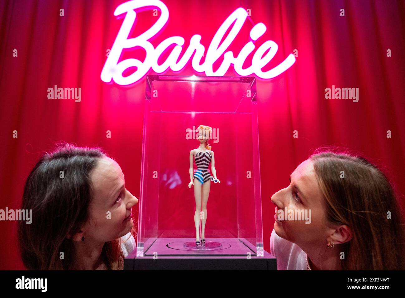 London, UK. 1 July 2024. Staff members with 'Number 1 Barbie', 1959 ...