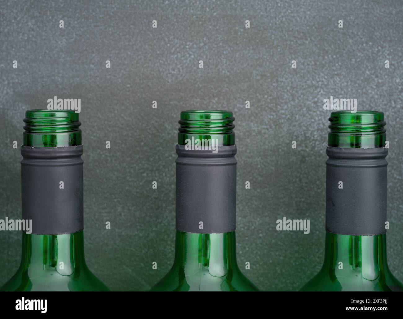 Three open wine bottles standing in a row against black background ...