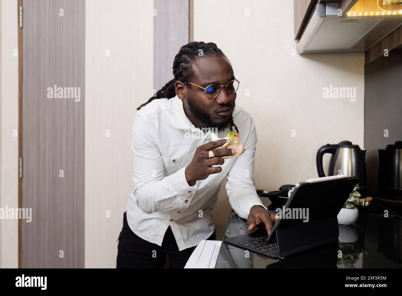 Young Professional Working from Home in Modern Kitchen with Tablet and ...