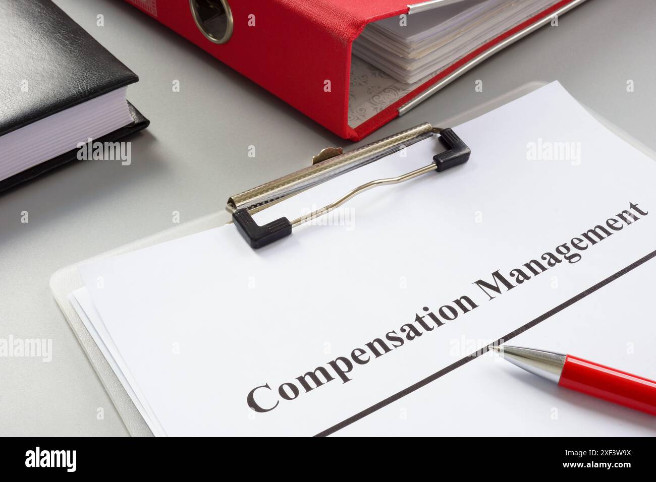 Compensation management rules and red folder Stock Photo - Alamy