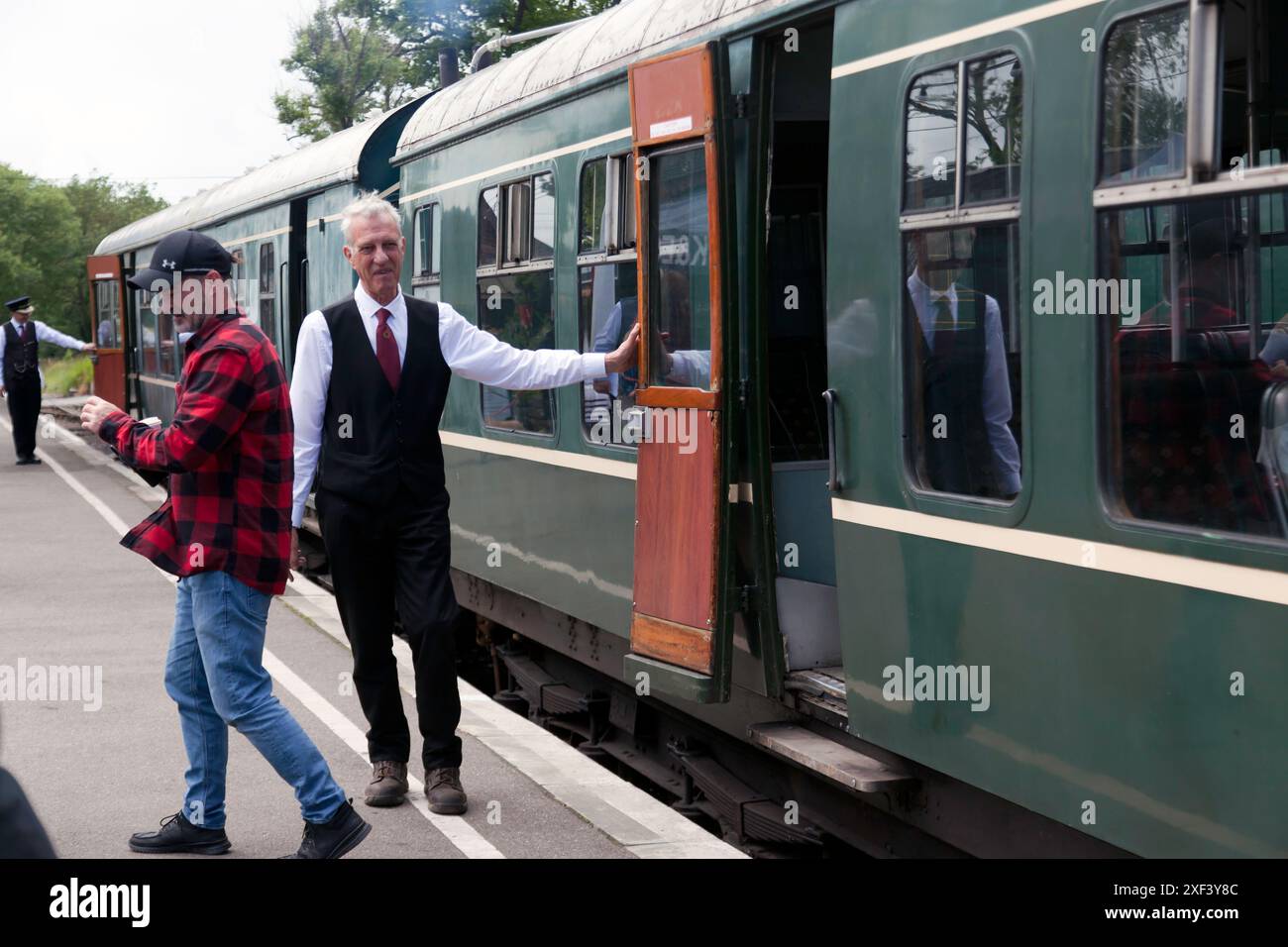 Stewards, in uniform, hold open the doors, as passengers disembark from ...