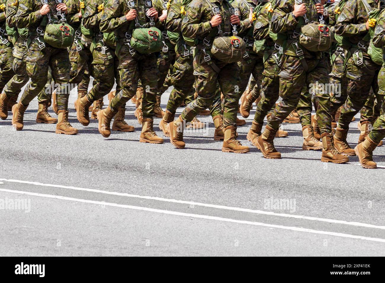 A squad of paratroopers marching in full army gear with parachutes down ...