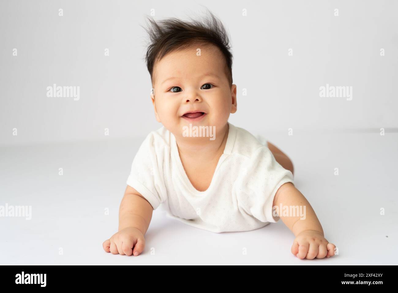 The baby boy is learning to crawl and playing with gum, white clothes ...
