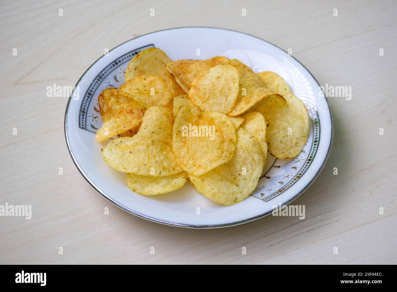 Potato chips on a white plate on wooden background. Crunchy delicious ...