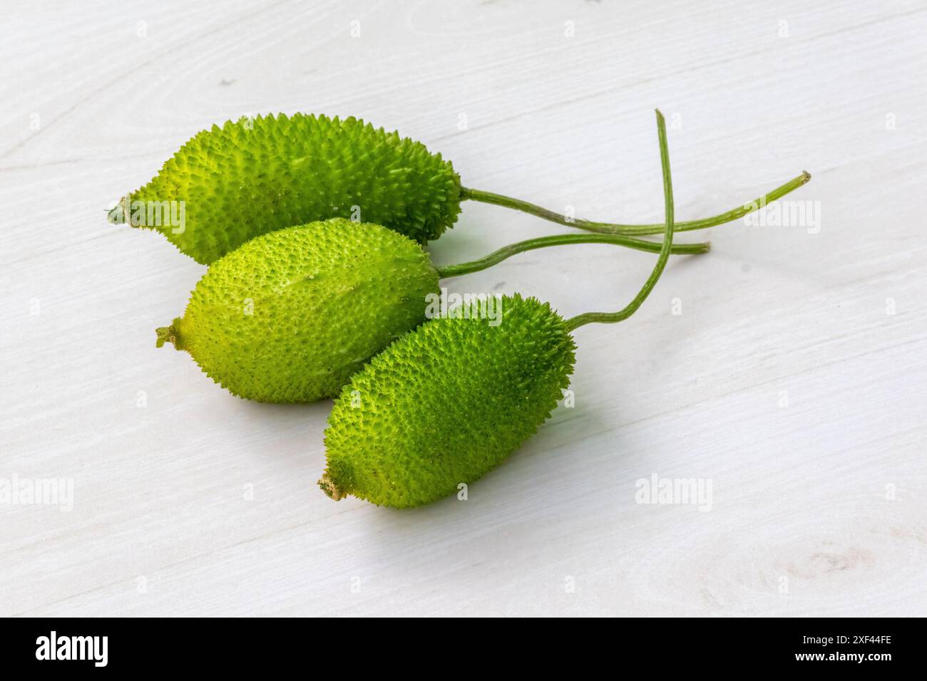 Three spiny gourd green vegetable on a wooden background. Momordica ...