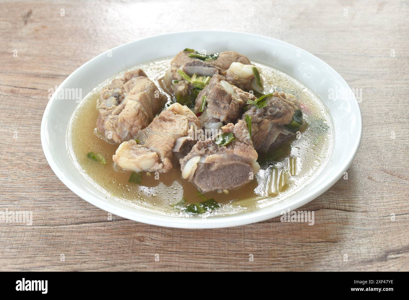 hot and spicy pork bone with tamarind and Thai herbs soup on plate ...
