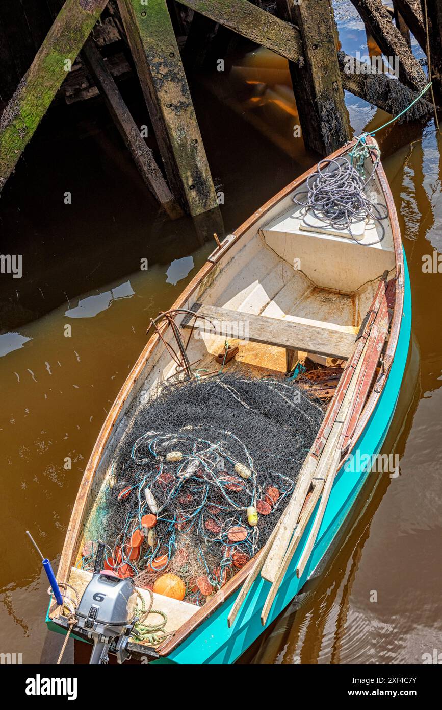 A small fishing boat loaded with nets seen from above. There is an ...