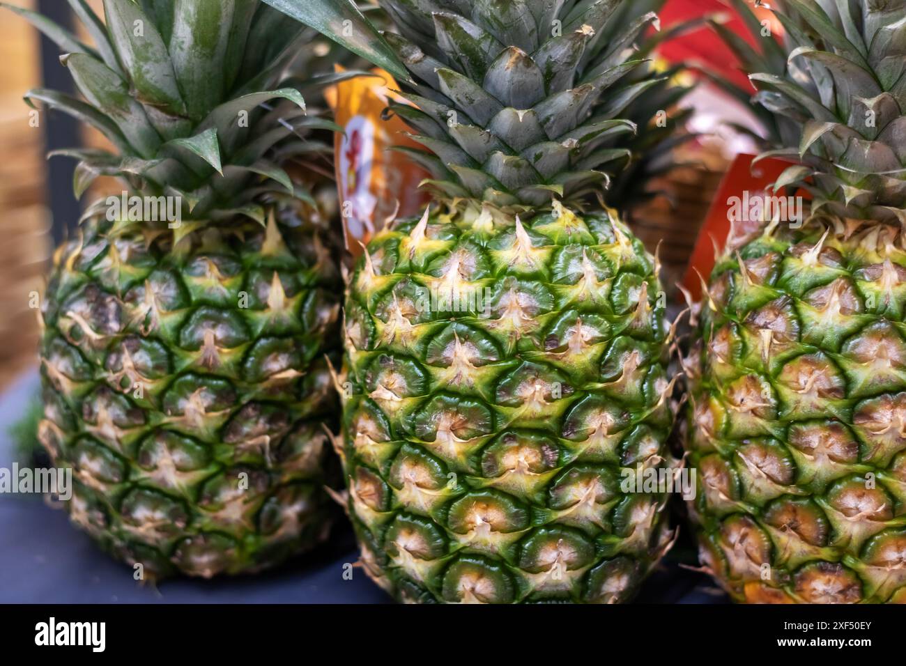 A collection of pineapples is placed on a tabletop, showcasing the ...