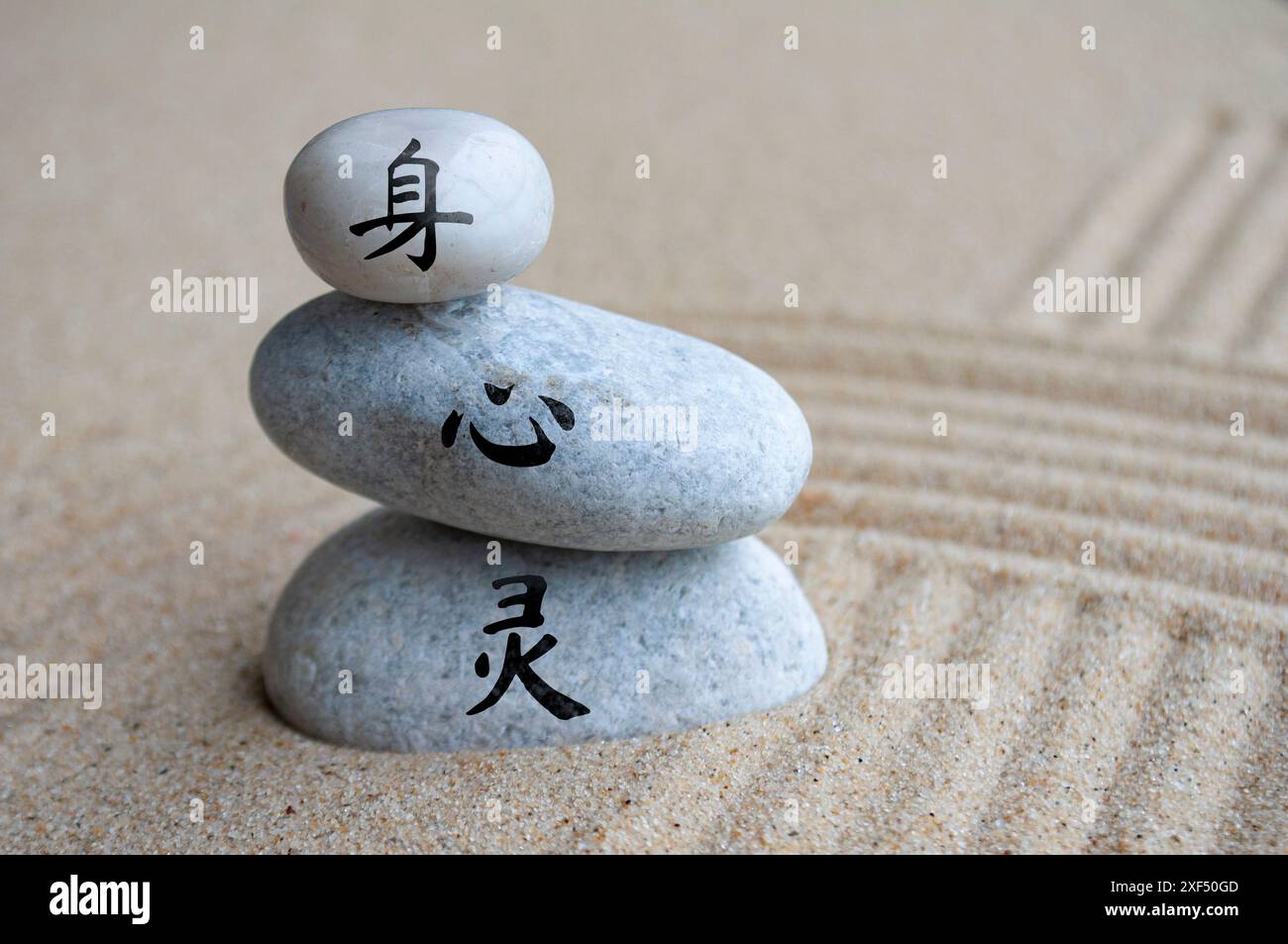 Body, mind and spirit in Chinese character on zen stones with sand ...