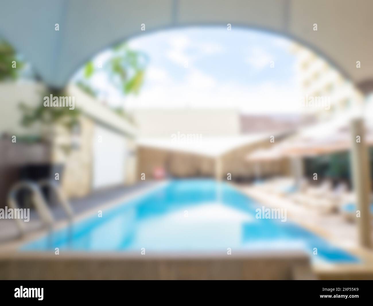 Abstract blur of blue outdoor swimming pool in open buildings at resort ...